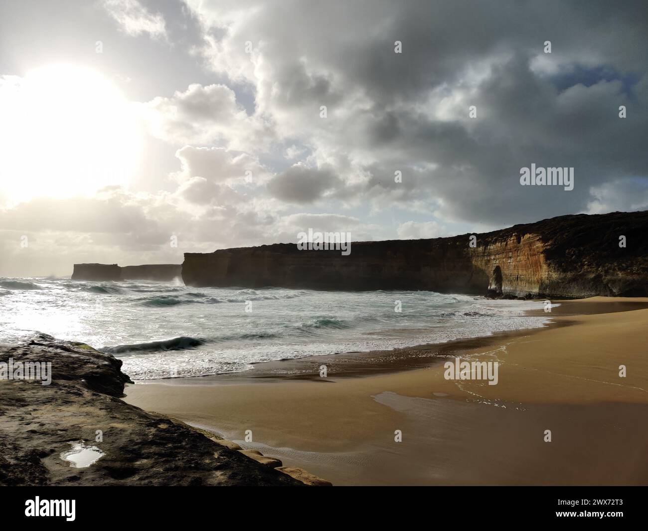 The scenic beach with waves and cliffs backdrop. Twelve Apostles ...