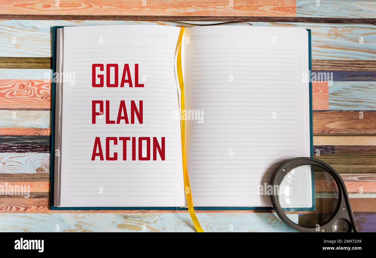 Goal, plan, action concepts with text in notepad and magnifying glass ...