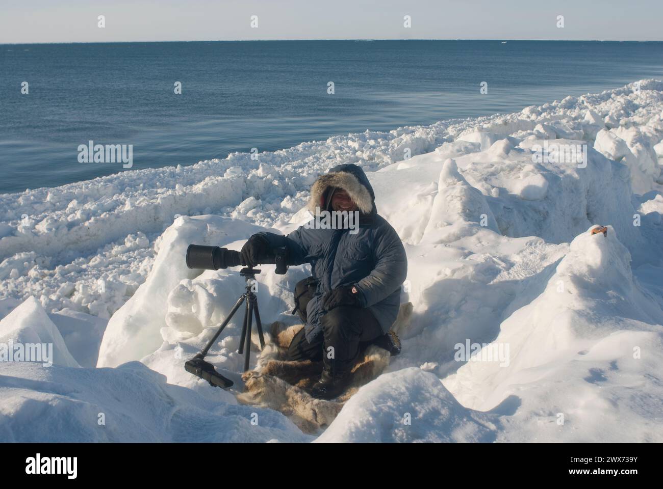 Photographer Steven Kazlowski with camera, tripod at the edge of an ...