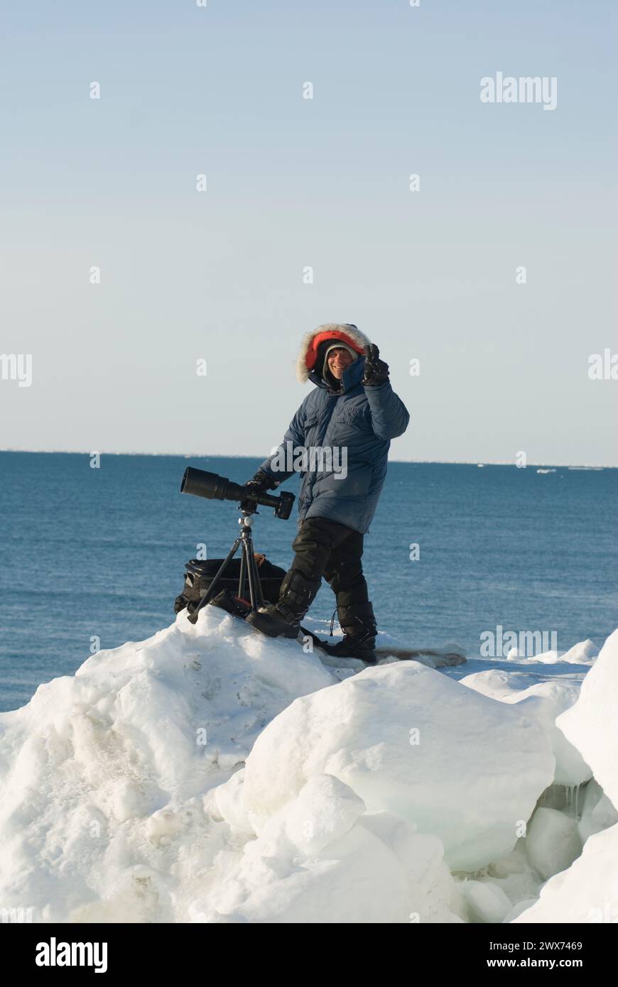 Photographer Steven Kazlowski with camera, tripod at the edge of an ...