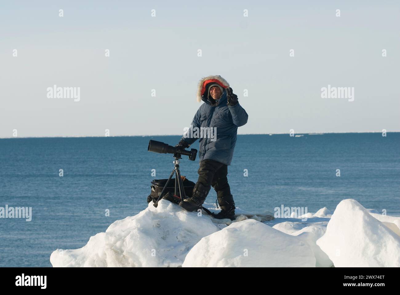 Photographer Steven Kazlowski with camera, tripod at the edge of an ...