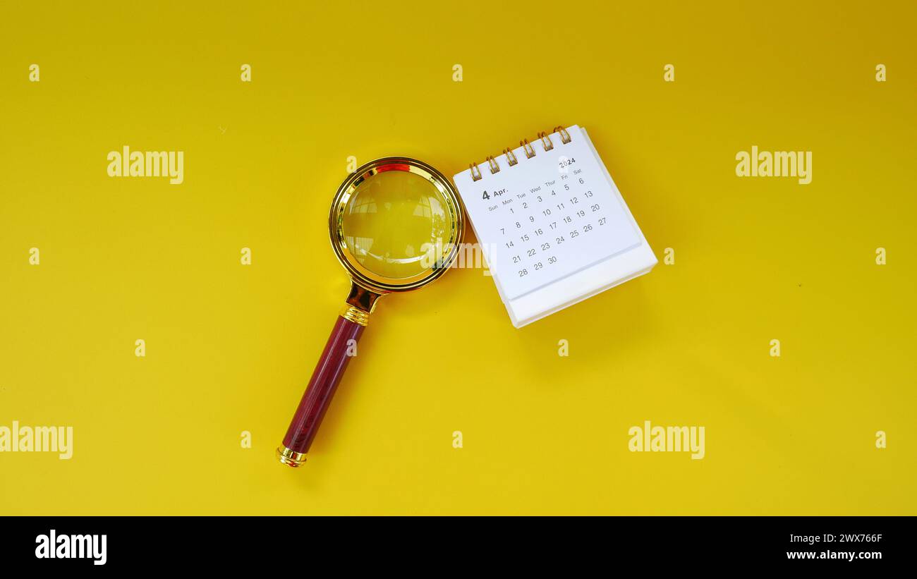 April 2024 calendar inside a magnifying glass Stock Photo - Alamy