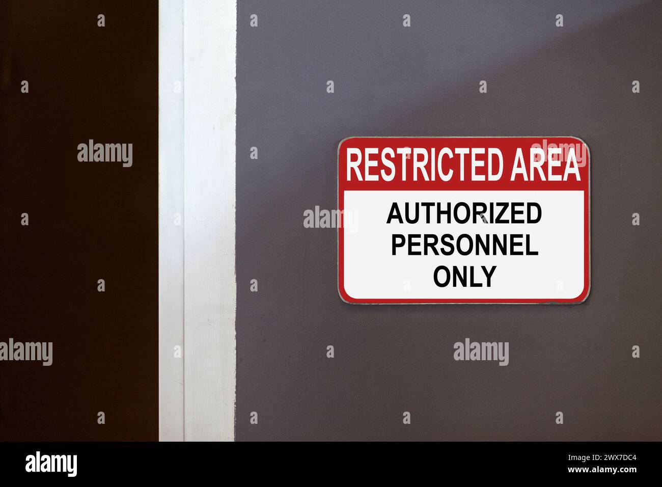 Red and white restricted area sign on the side of a corridor stating ...