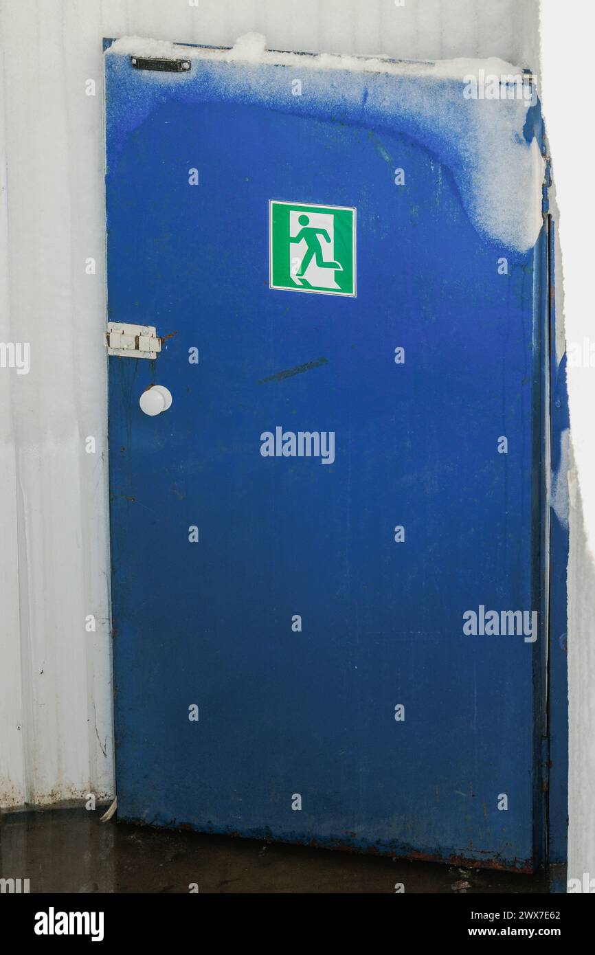 Open metal door of emergency emergency exit from building with sign ...