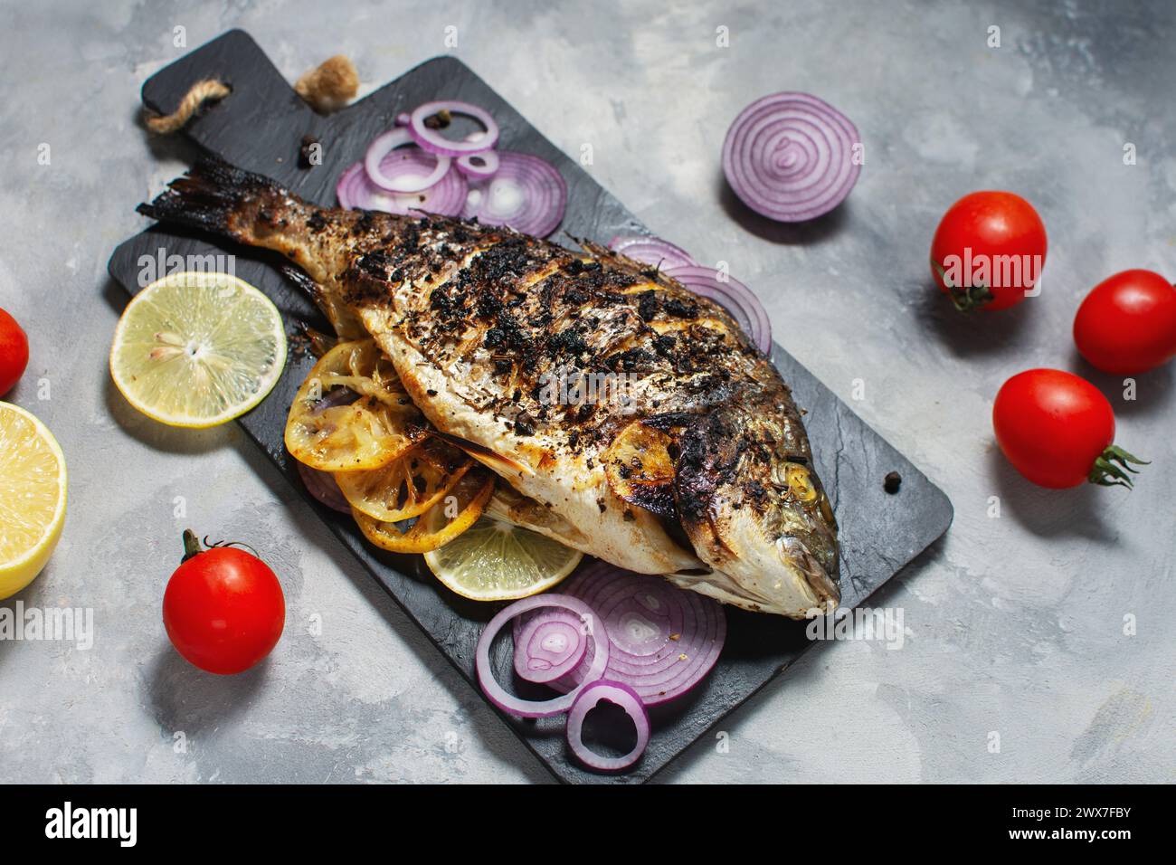 Baked fish dorado. Sea bream or dorada fish grilled on a concrete ...