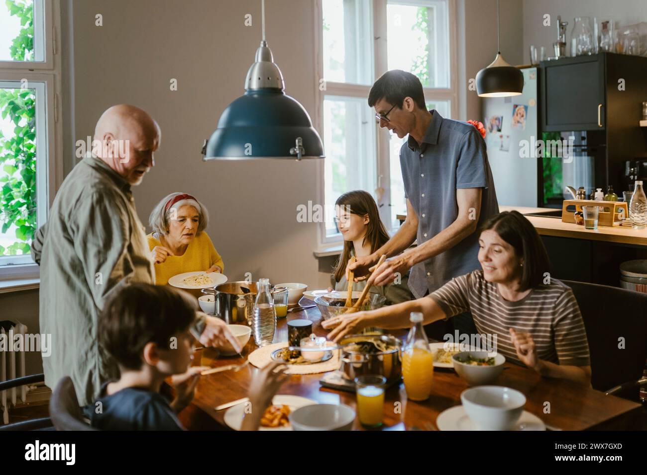 Multi-generation family having dinner at dining table in home Stock ...
