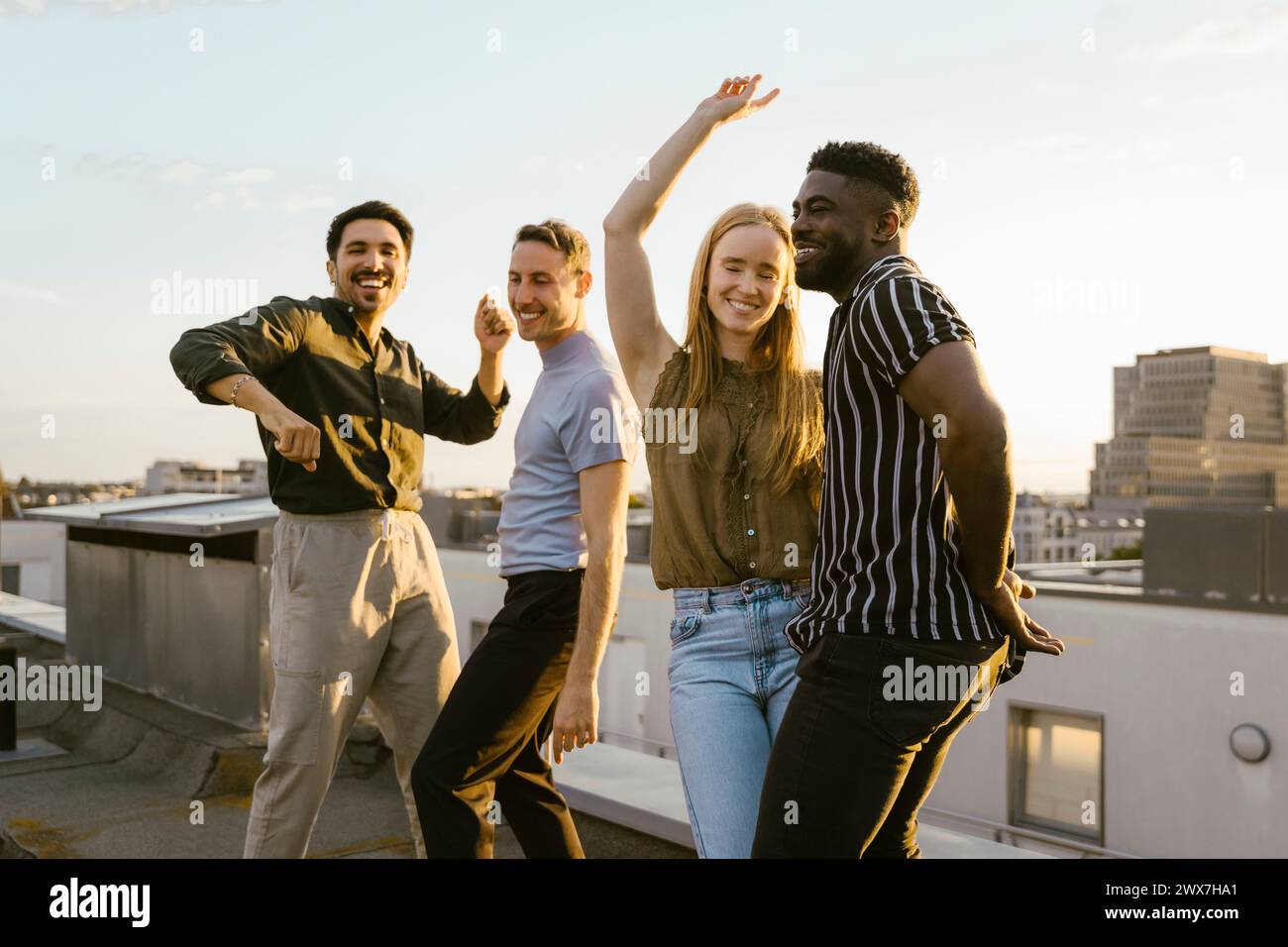 Group of happy male and female having fun while dancing on building ...