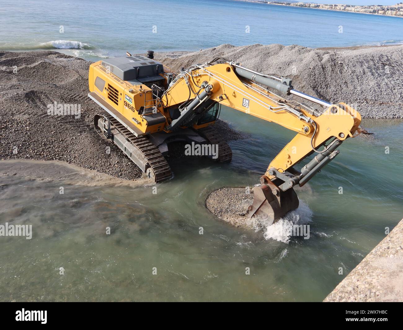 Big yellow machines: an excavator with caterpillar tracks & bucket digs ...