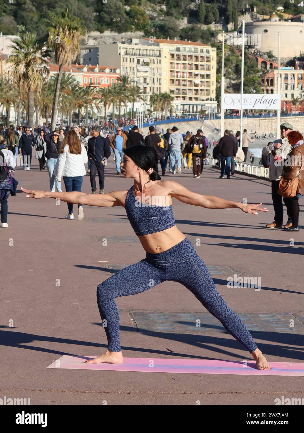 Yoga positions on the Promenade des Anglais in Nice: a young woman ...