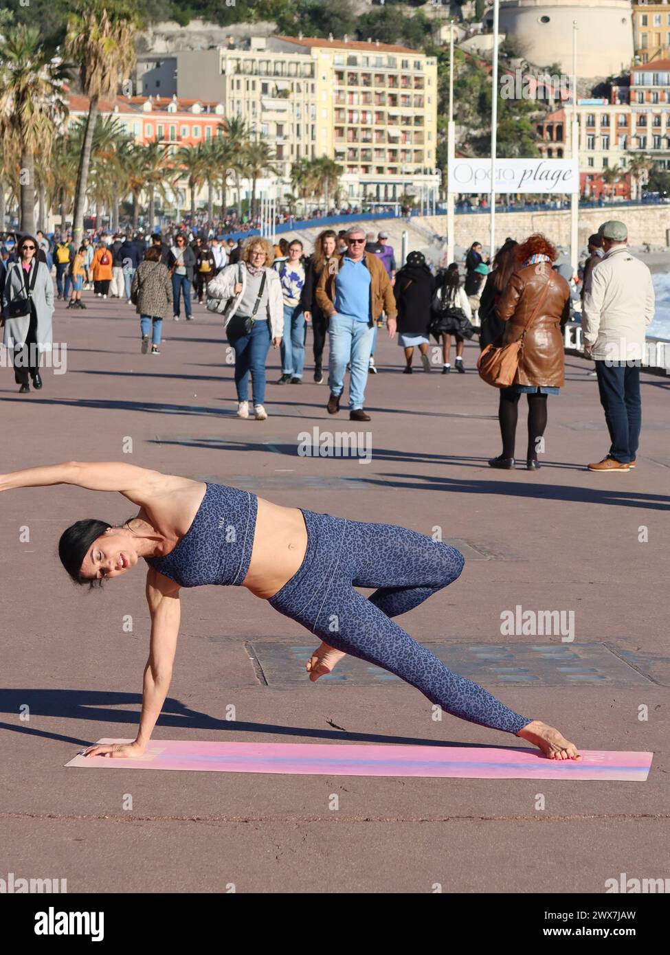 Yoga positions on the Promenade des Anglais in Nice: a young woman ...