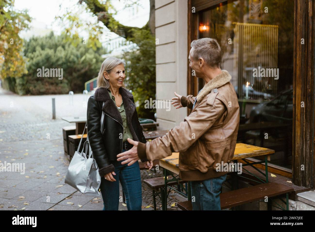 Man greeting woman arriving at date near restaurant Stock Photo - Alamy