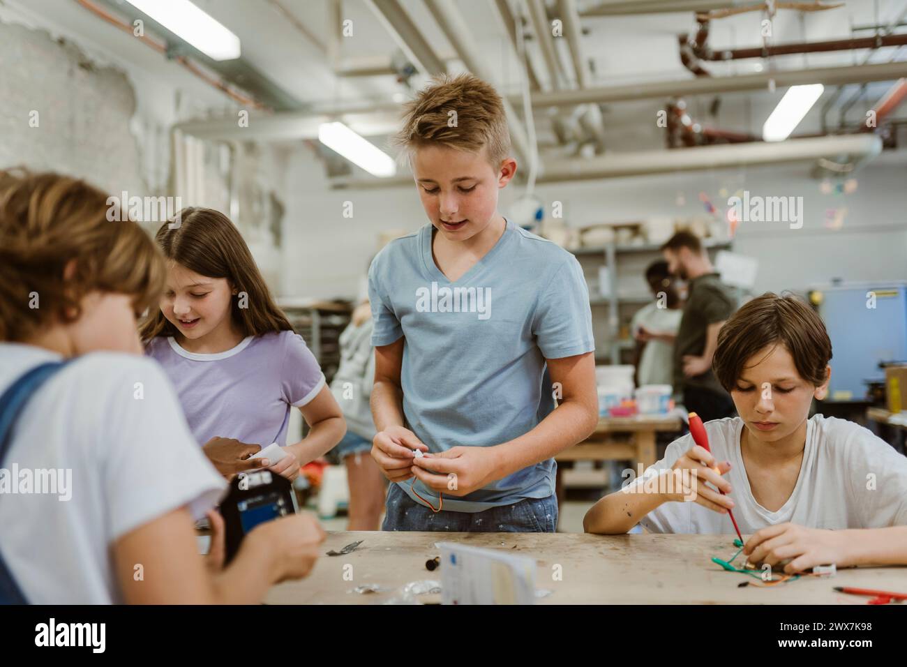 Group of male and female students working with electrical components in ...