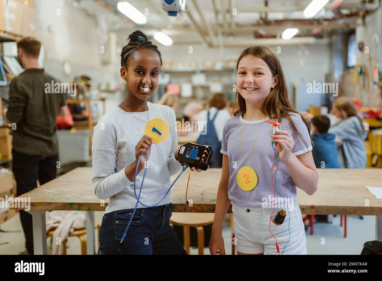 Portrait of smiling female students showing number ranks while holding ...