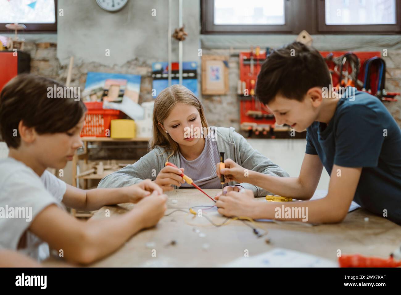 Curious male and female school students working on robotics project in ...