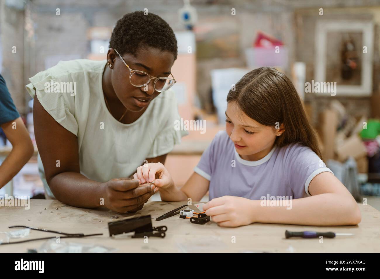 Female teacher helping student working on robotics project in ...