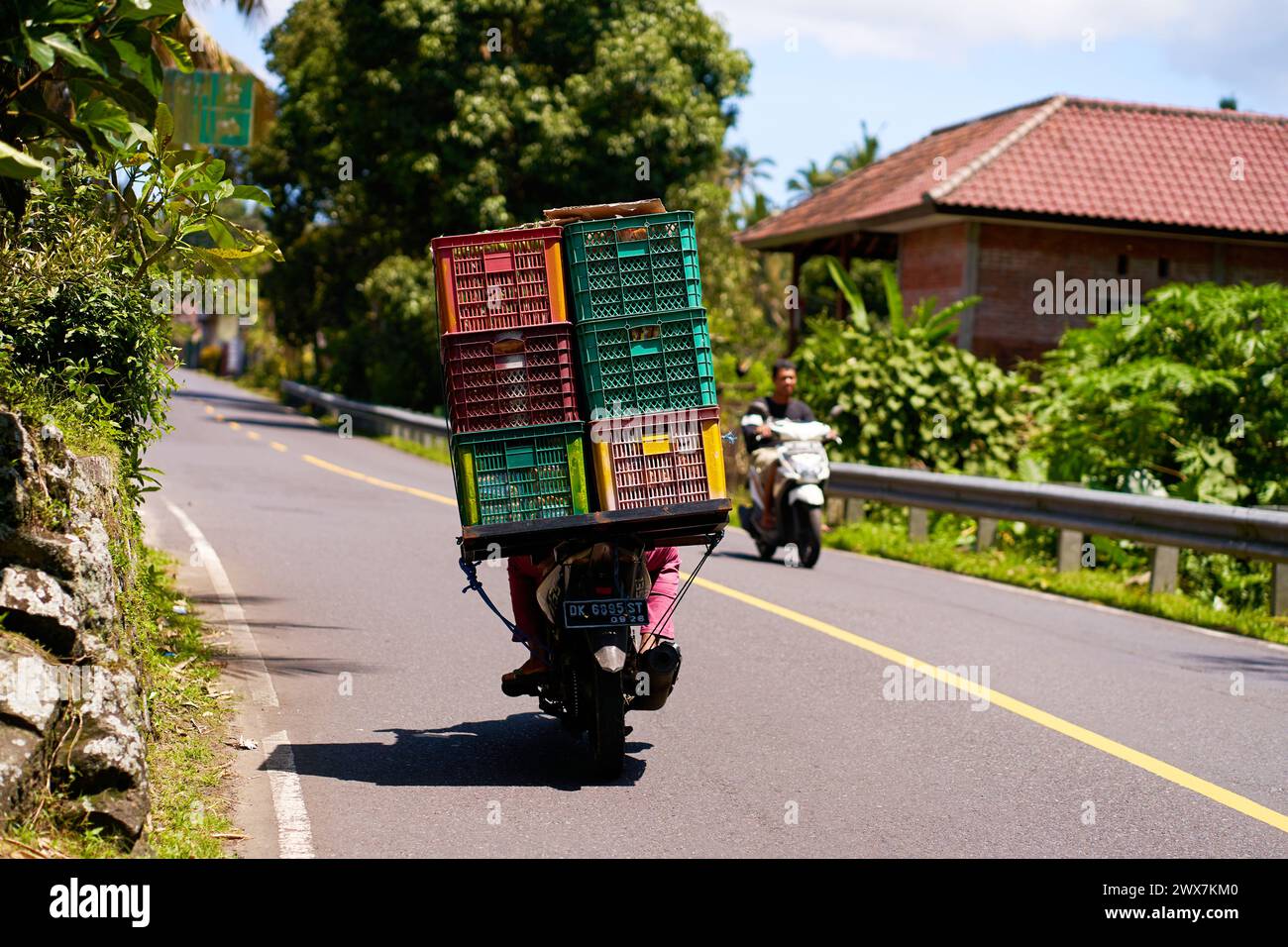 People are riding a heavily loaded motorcycle. Asian people are ...