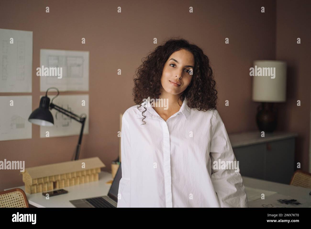 Portrait of confident female architect wearing white shirt at office ...