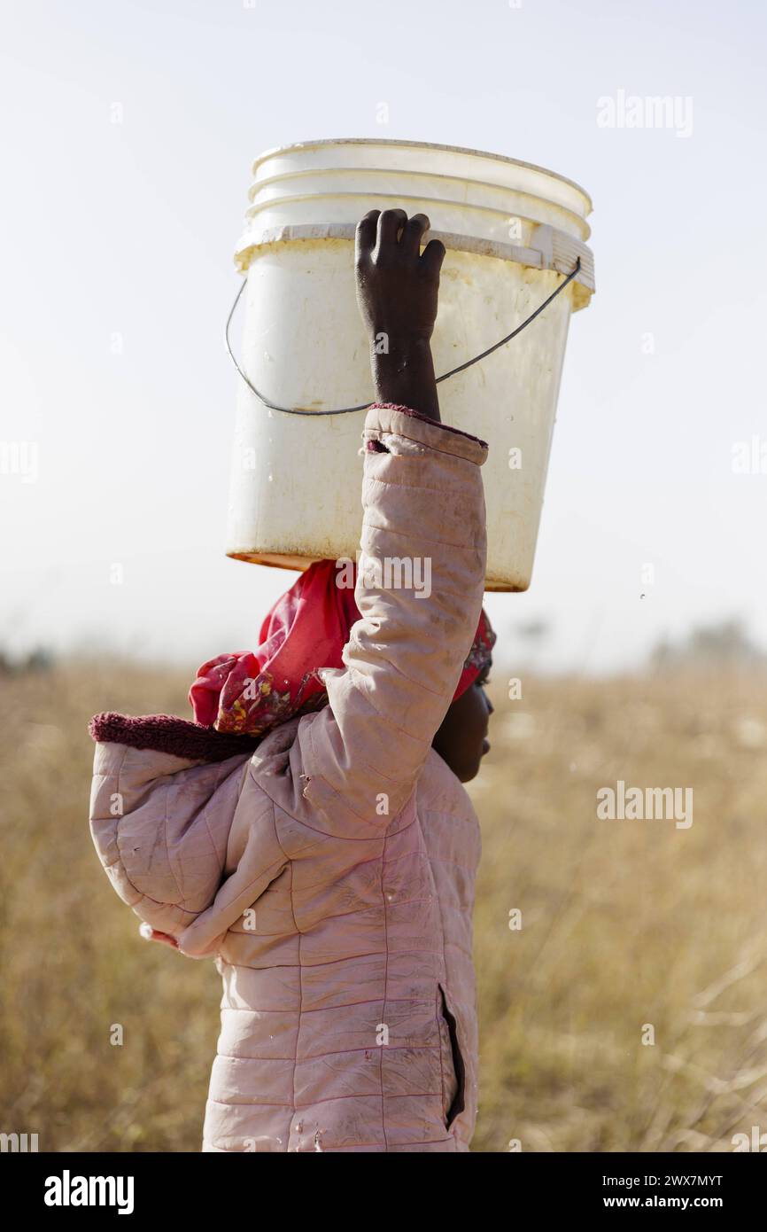 Girl carrying a bucket hi-res stock photography and images - Alamy