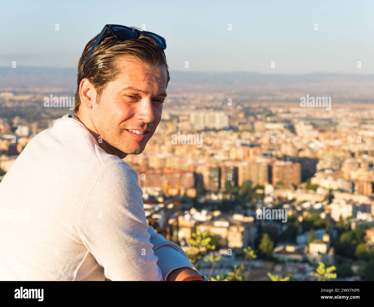 Thoughtful man in his thirties looking down at a panoramic view of the ...
