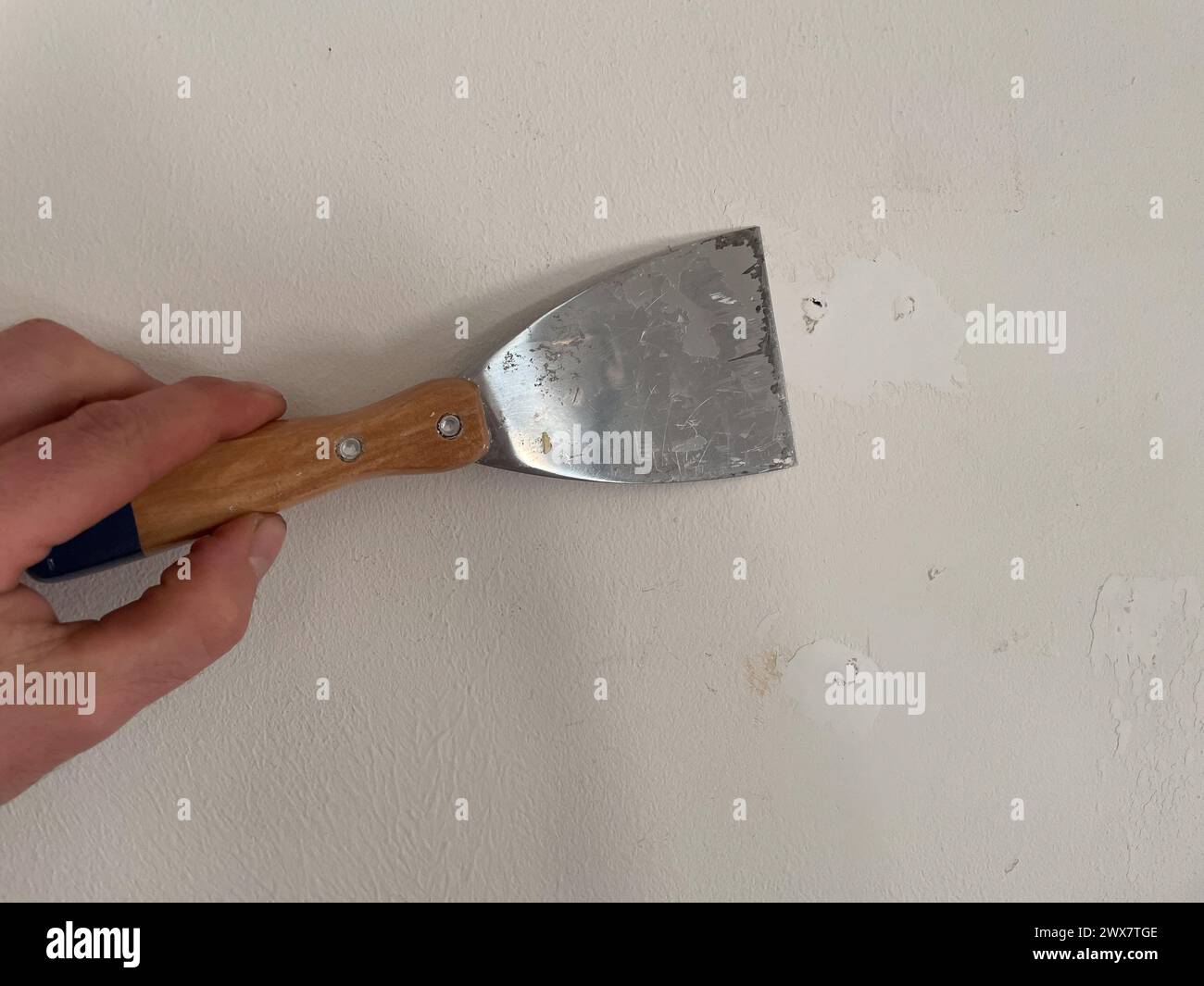 Spatula on a wall while fixing in a room Stock Photo - Alamy