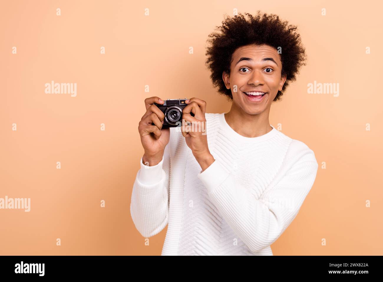 Photo of cheerful man photographer hold vintage polaroid camera stand ...