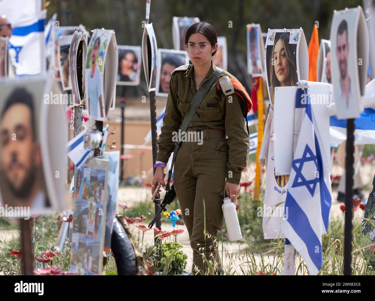An armed Israeli army officer tours the memorial site in Re'im ...
