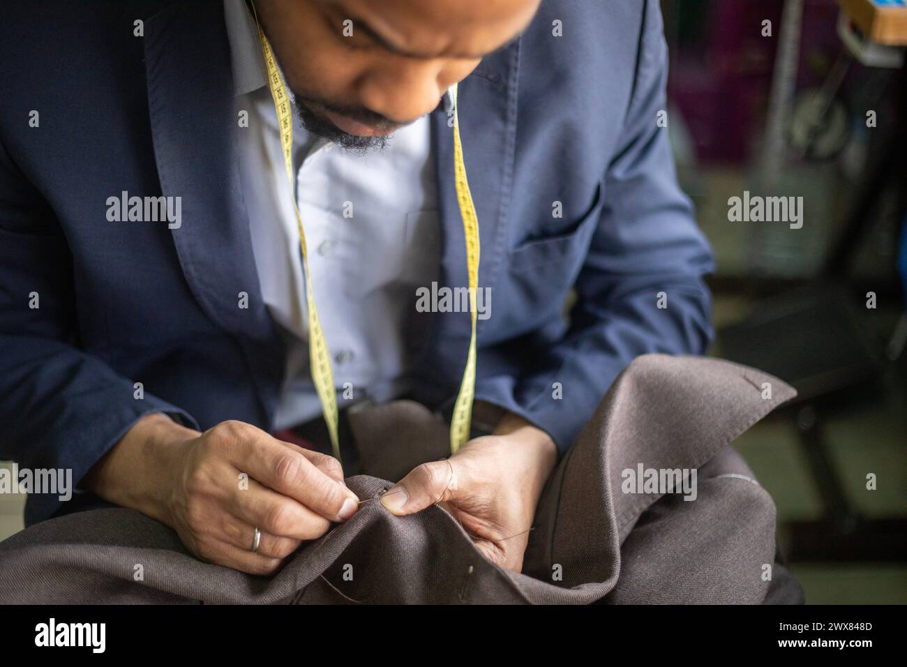 Detailed close up photo of a young African American tailor hand ...