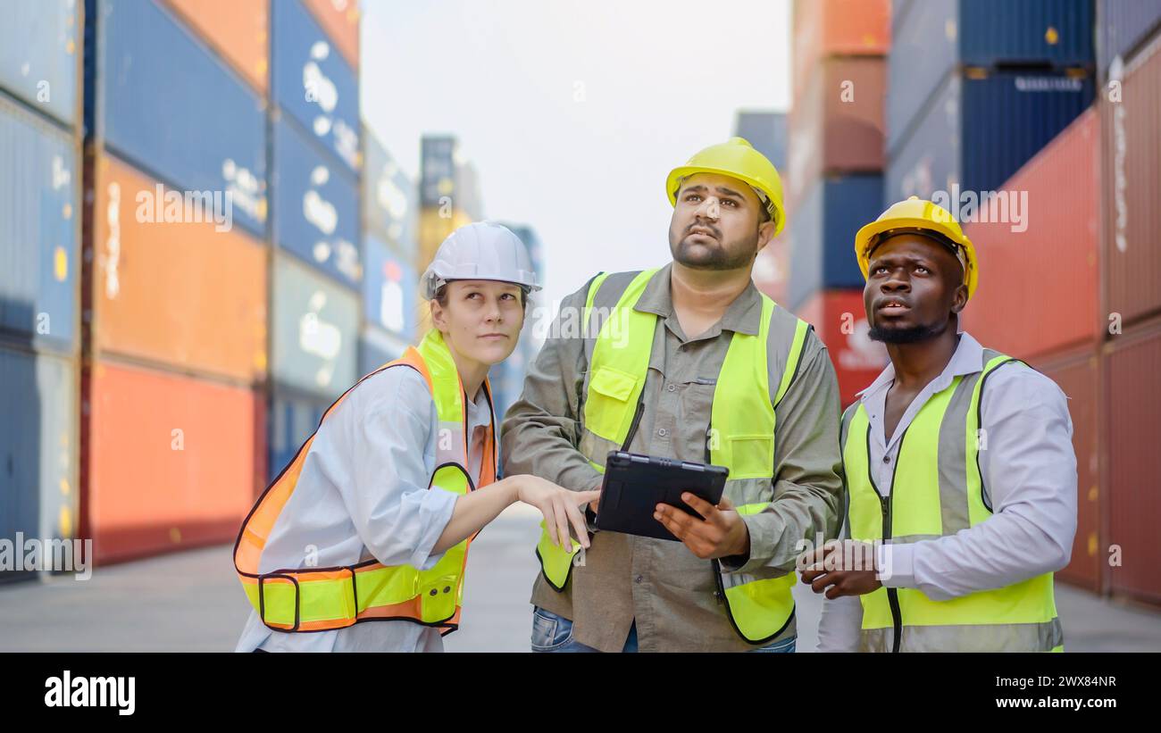 Three workers in front of containers at an industrial site Stock Photo ...