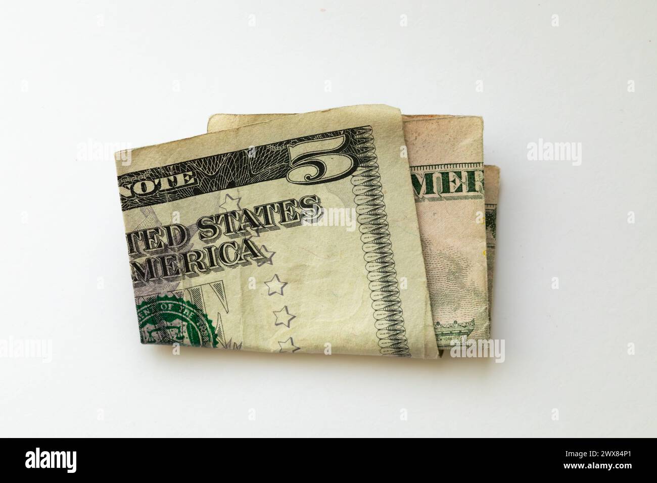 folded five American dollar bill on white Stock Photo - Alamy