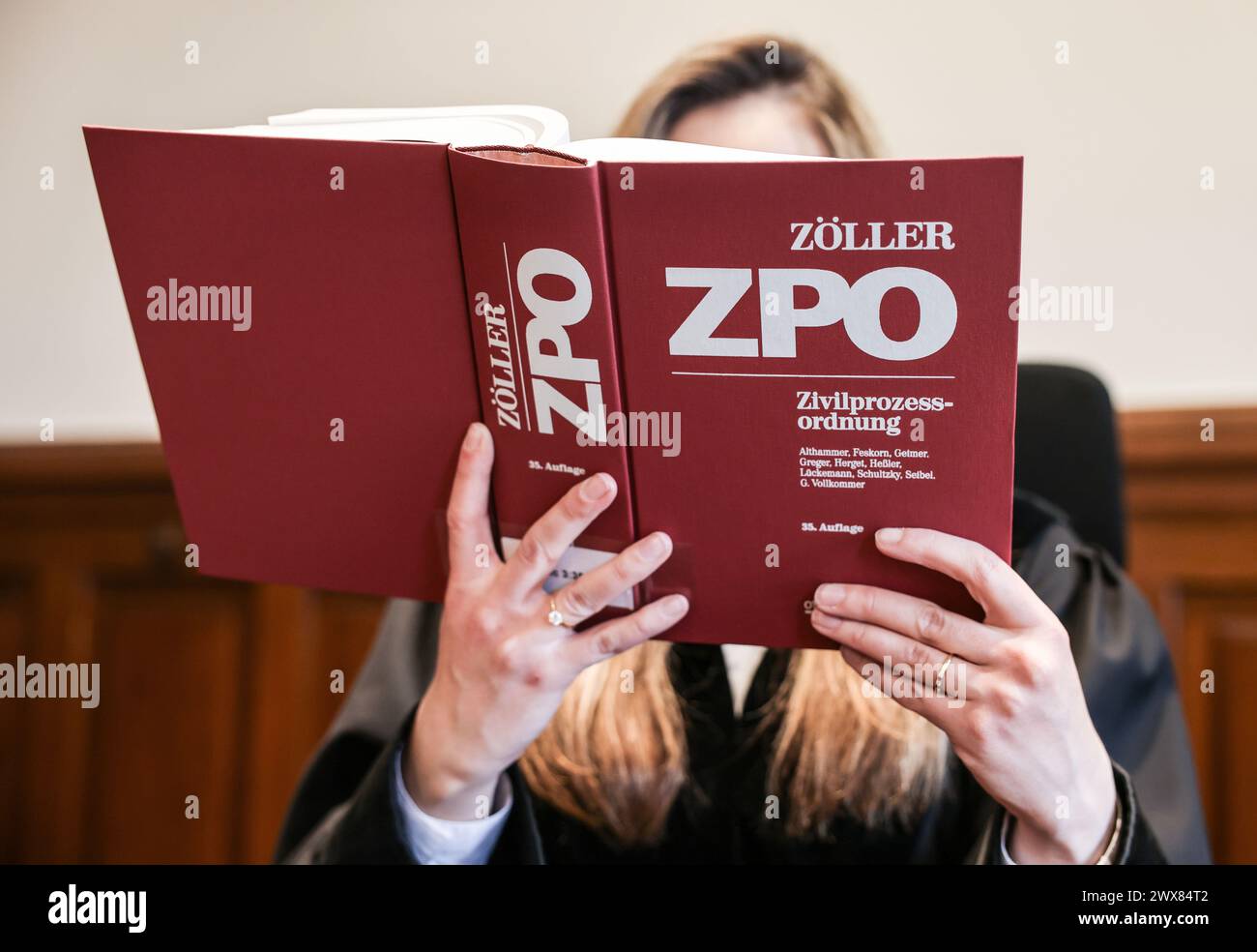 Cologne, Germany. 21st Mar, 2024. A lawyer reads the Code of Civil ...