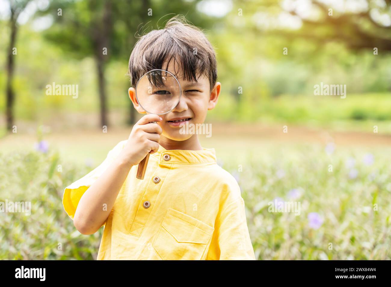 A young boy stands in a field, holding an object Stock Photo - Alamy
