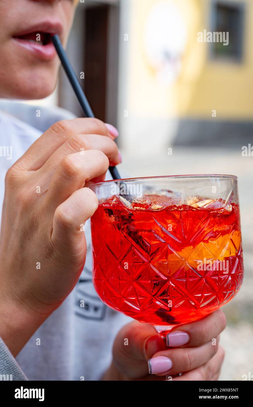 Drinking of Spritz Campari red bitter long drink cocktail maid with ...