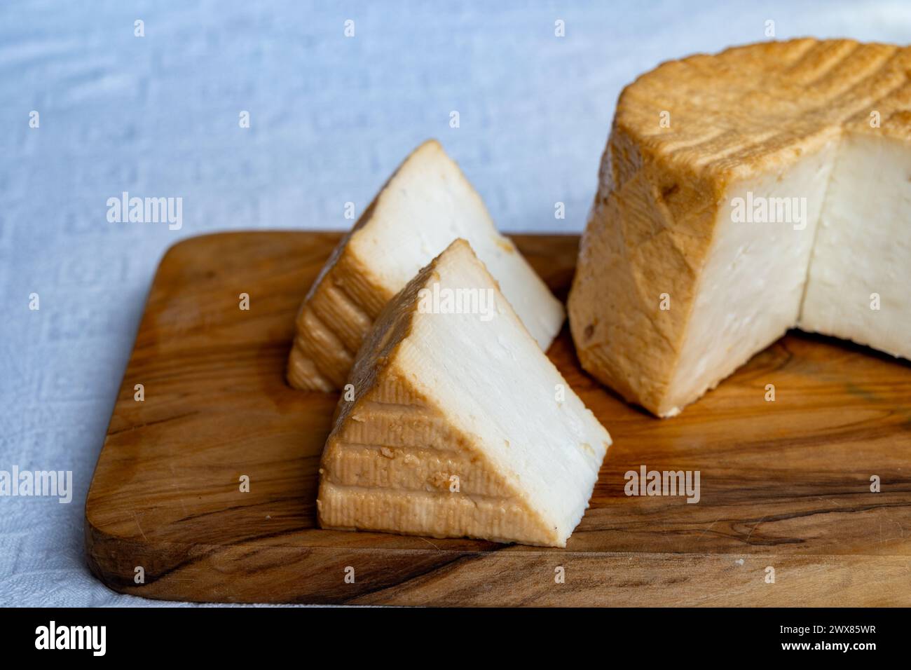 Cheese collection, piece of round fresh smoked Spanish goat cheese ...