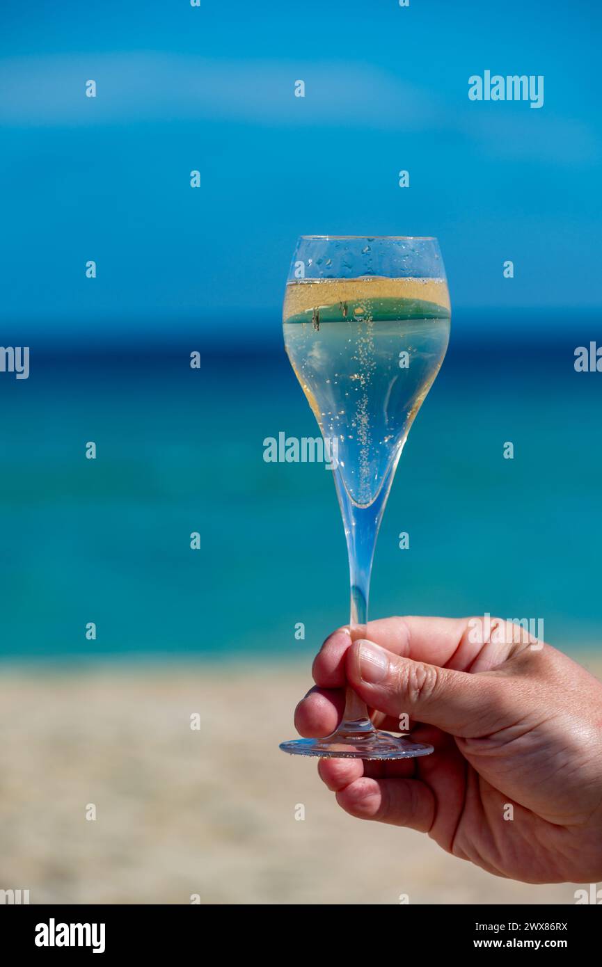 Hand with glass of cava or champagne sparkling wine on vacation, Dunes ...