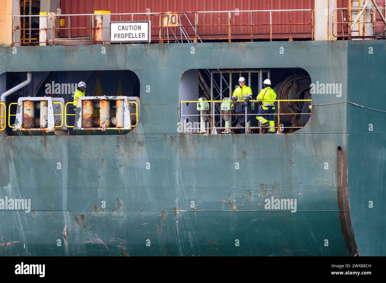The crew of a container ship on deck as their ship departs port Stock ...
