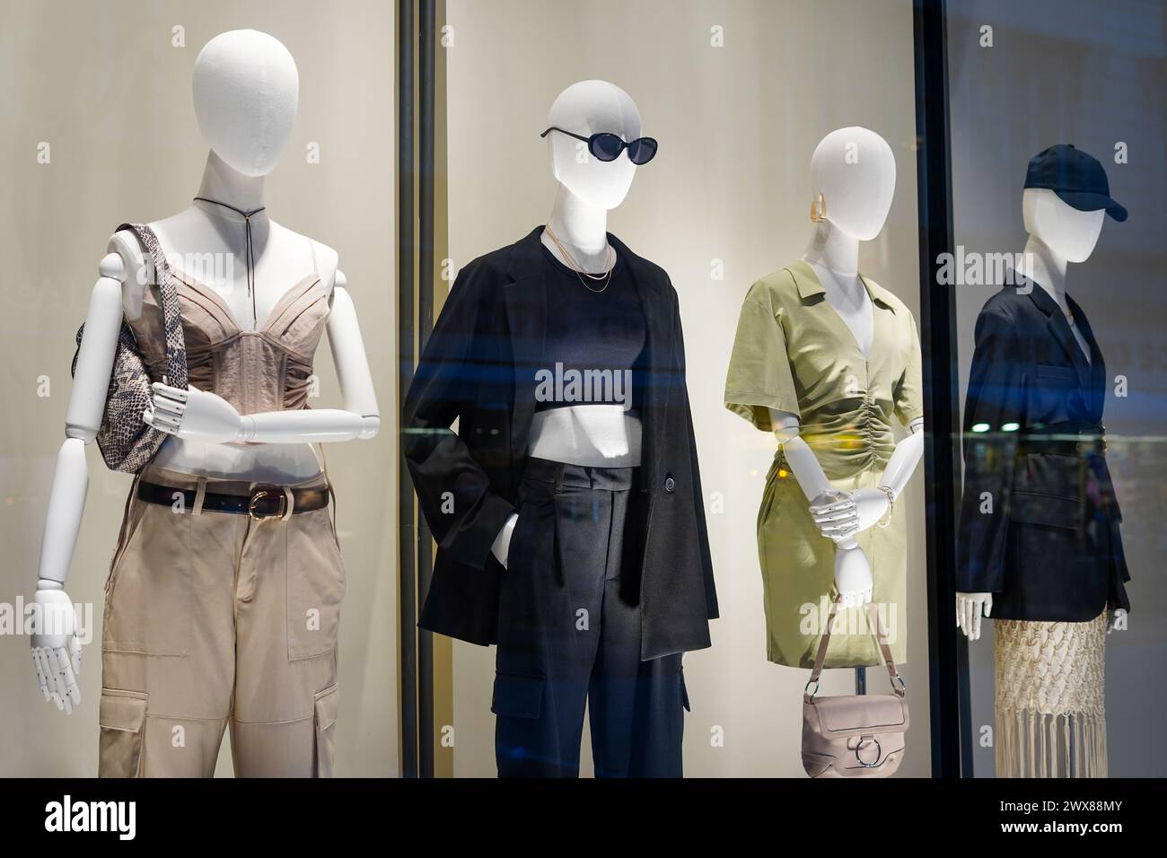 four mannequins in stylish clothes shop window Stock Photo - Alamy