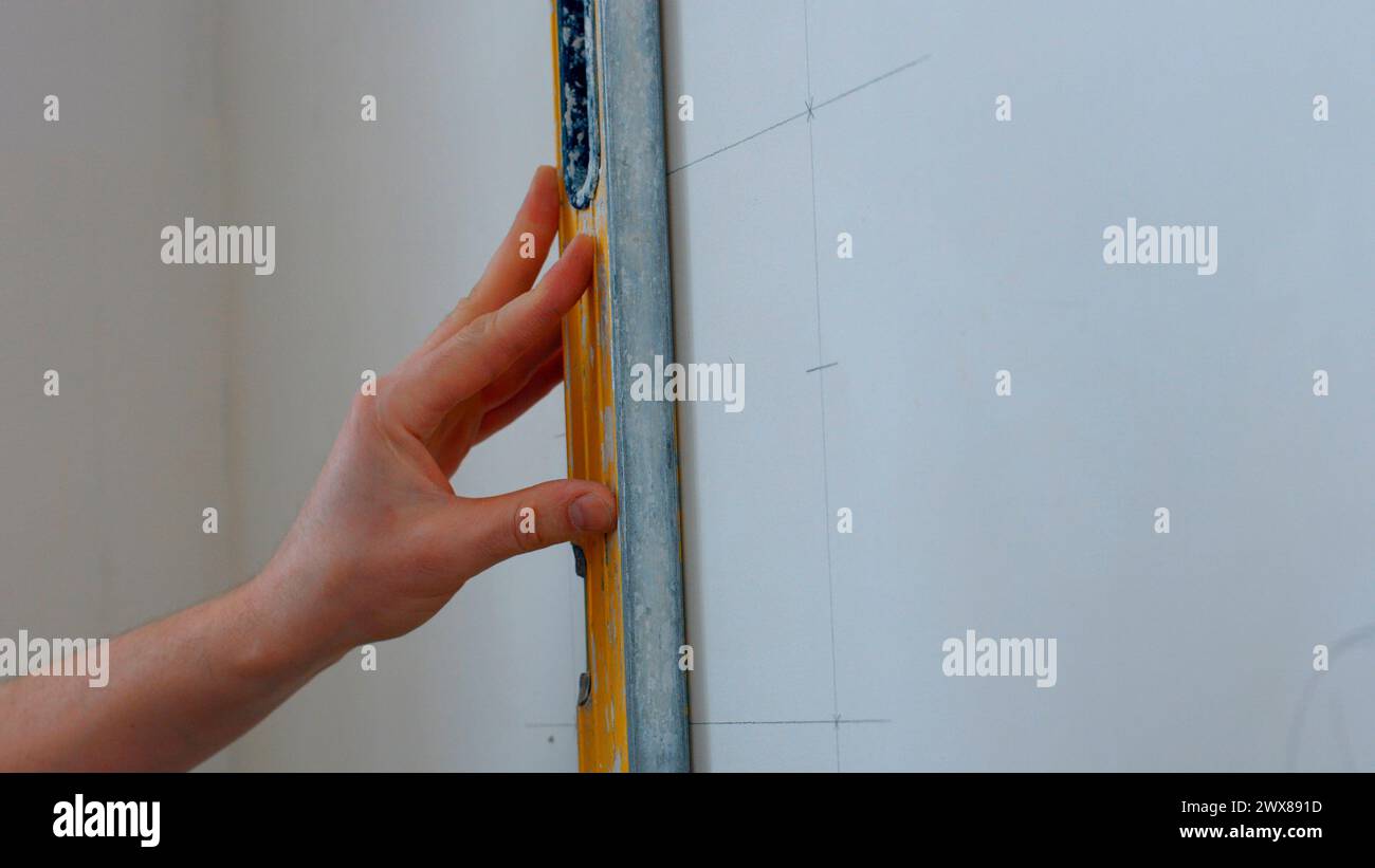 A specialist draws markings on the wall. Lines are drawn for future ...
