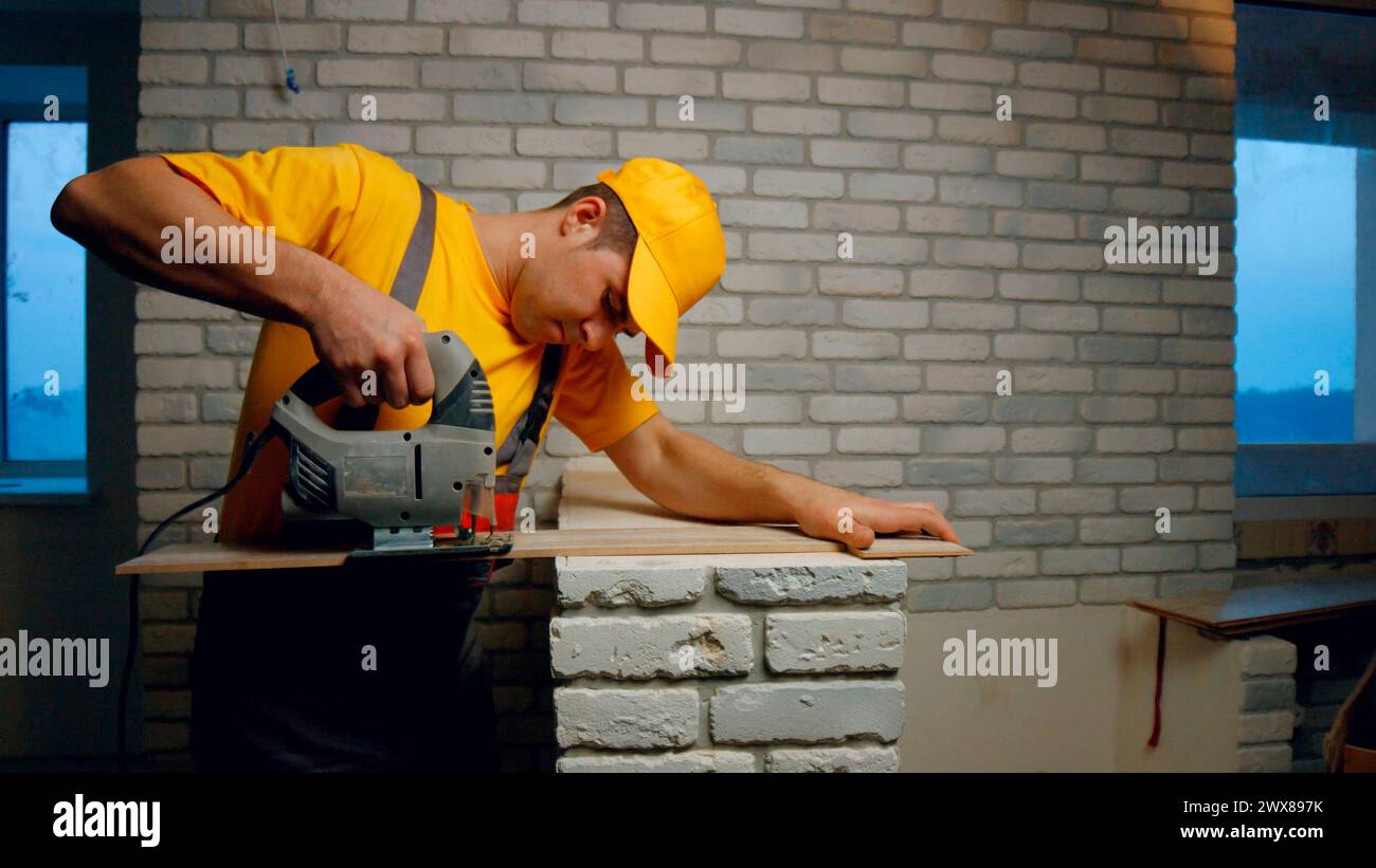 Builder cuts laminate. Worker cut by electric saw floorboard Stock ...