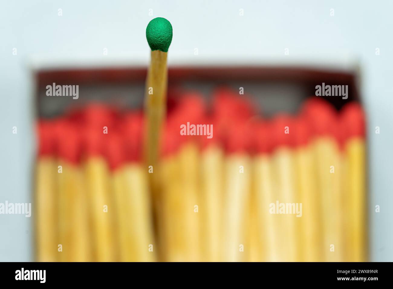 Set of several defocused red-headed matchsticks with one green-headed ...