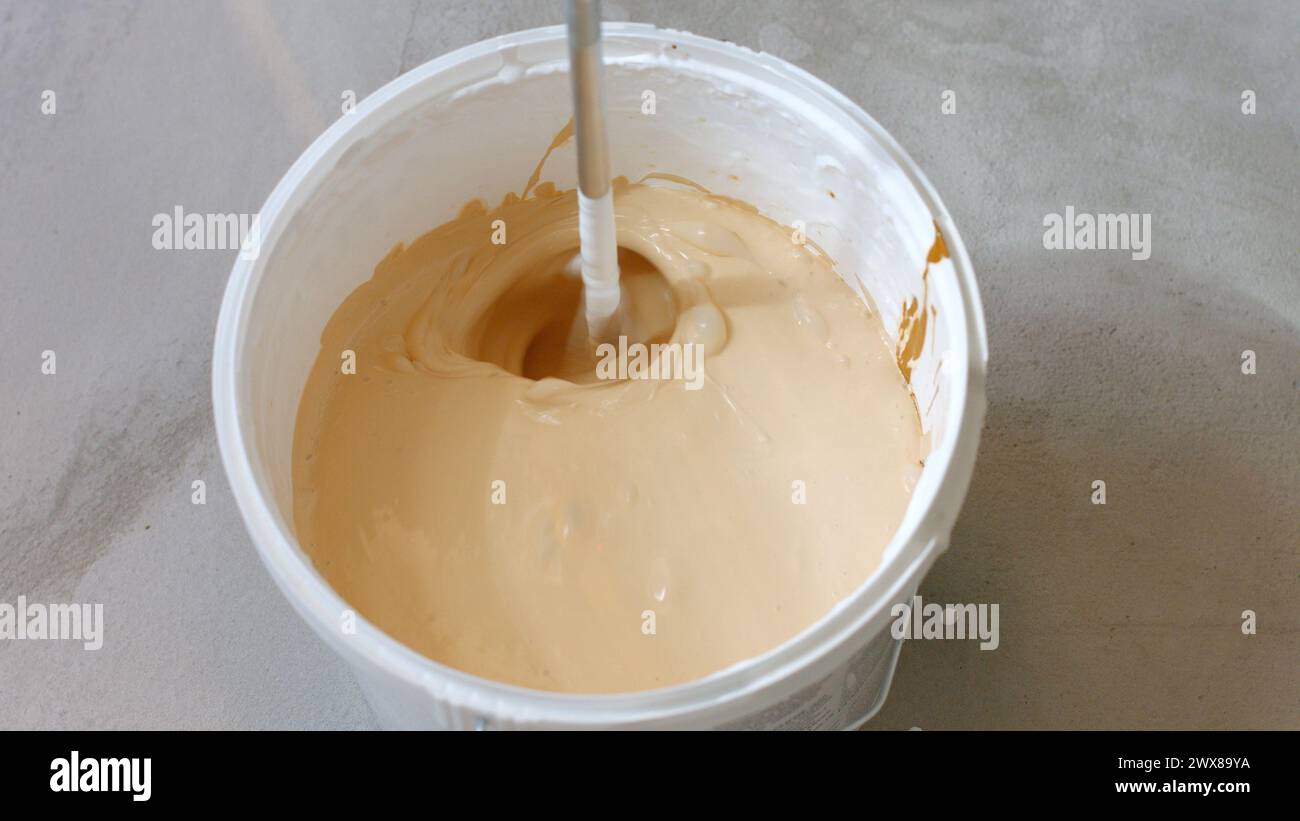 Mixer mixes the paint. Preparation for painting the walls Stock Photo ...