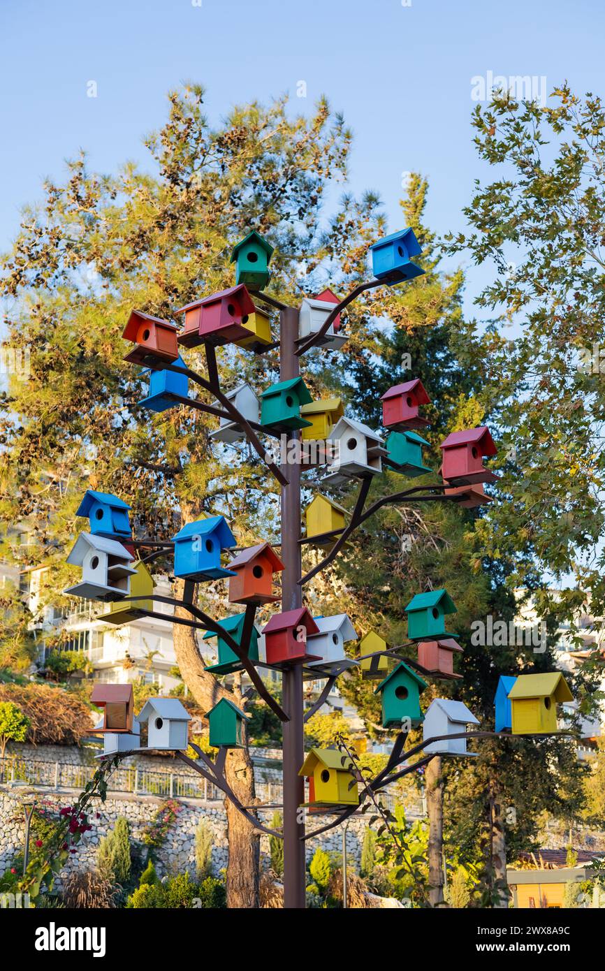 Colorful birdhouses on a decorative tree with a natural backdrop Stock ...