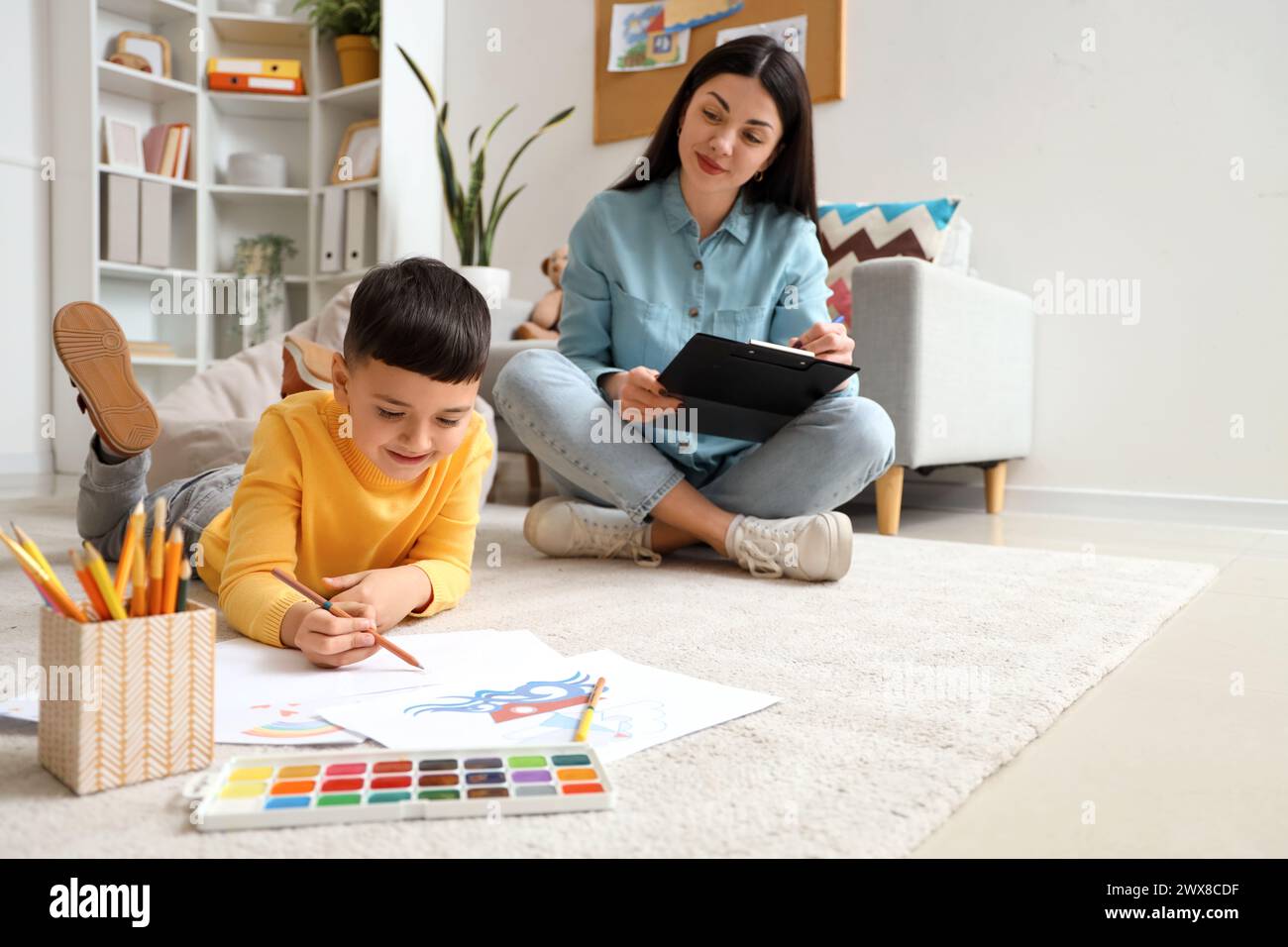 Little boy with psychologist drawing in office Stock Photo - Alamy