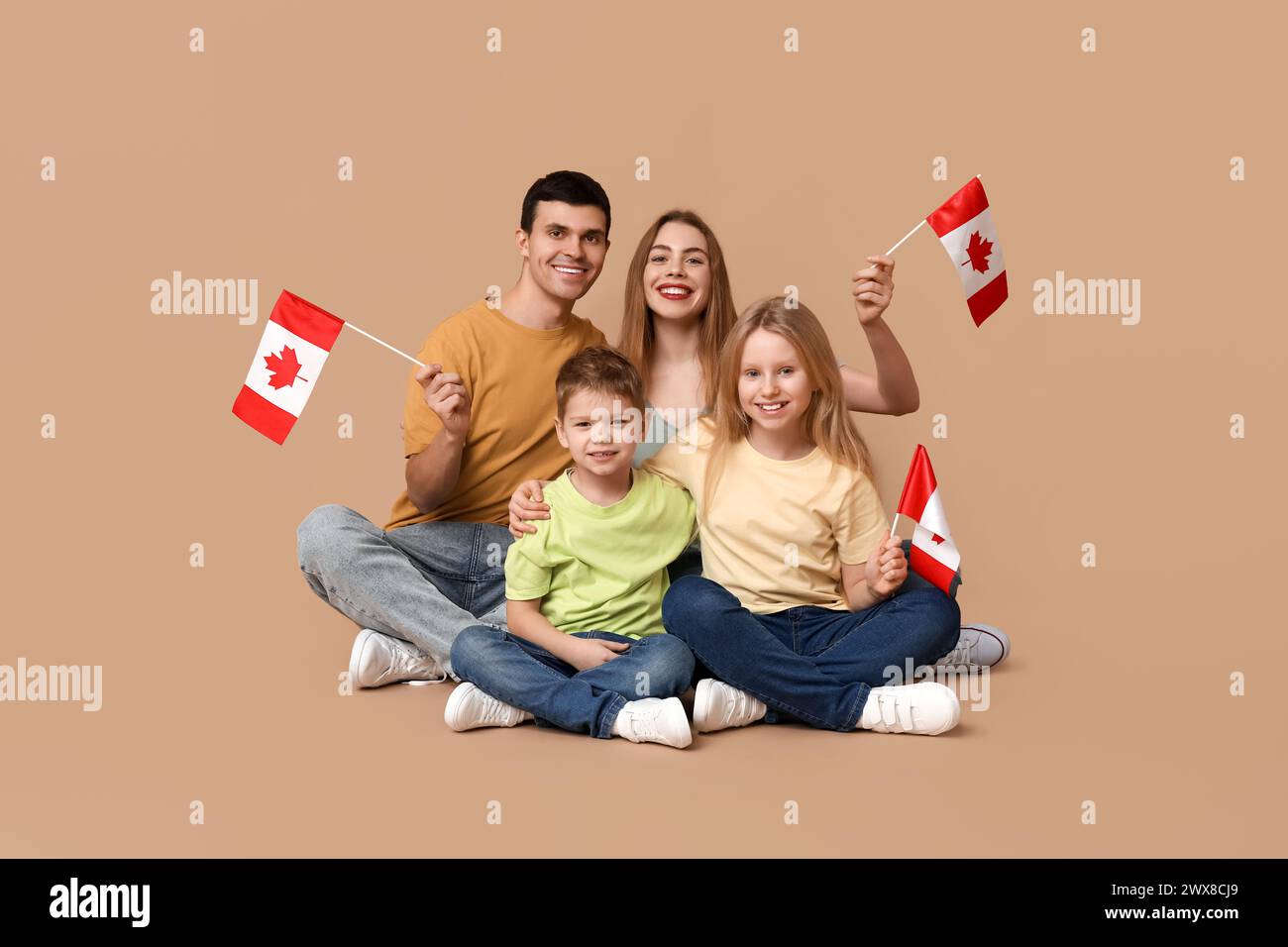 Happy family with flags of Canada sitting on brown background Stock ...
