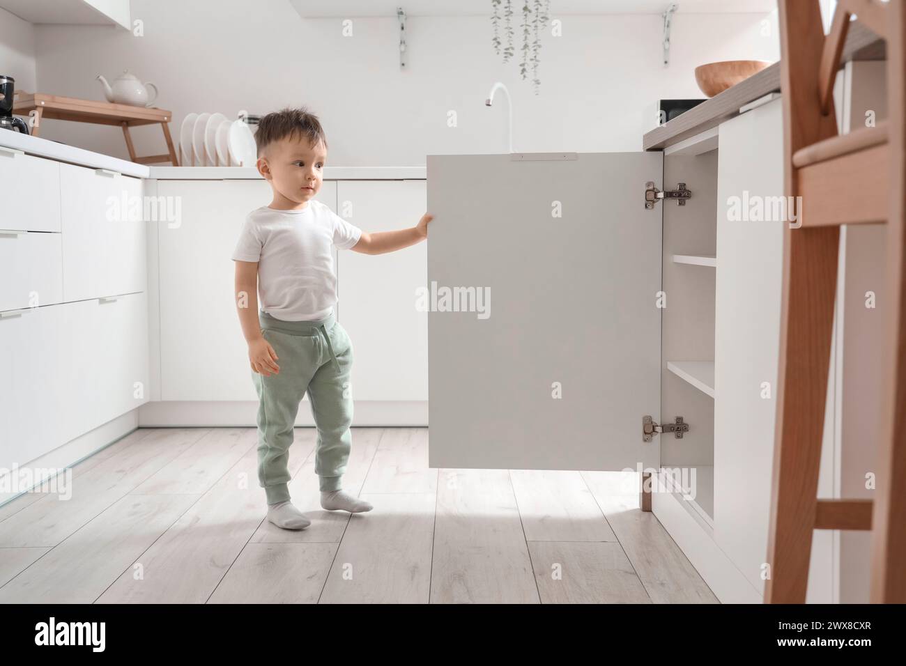 Little boy opening drawer in kitchen. Child at risk Stock Photo - Alamy