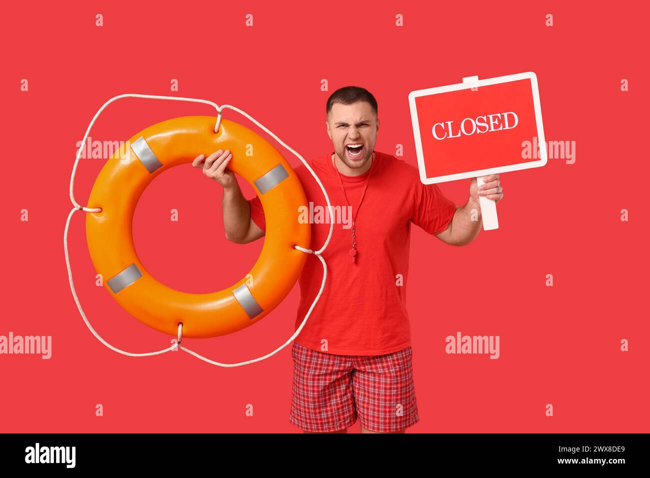 Shouting young lifeguard with lifebuoy and sign "closed" on red ...
