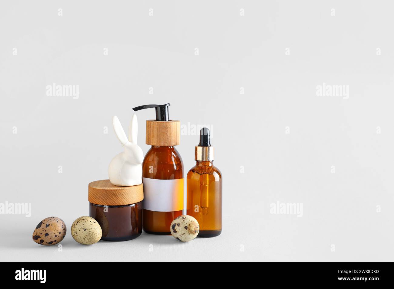Set of cosmetic products, Easter eggs and ceramic bunny on light ...