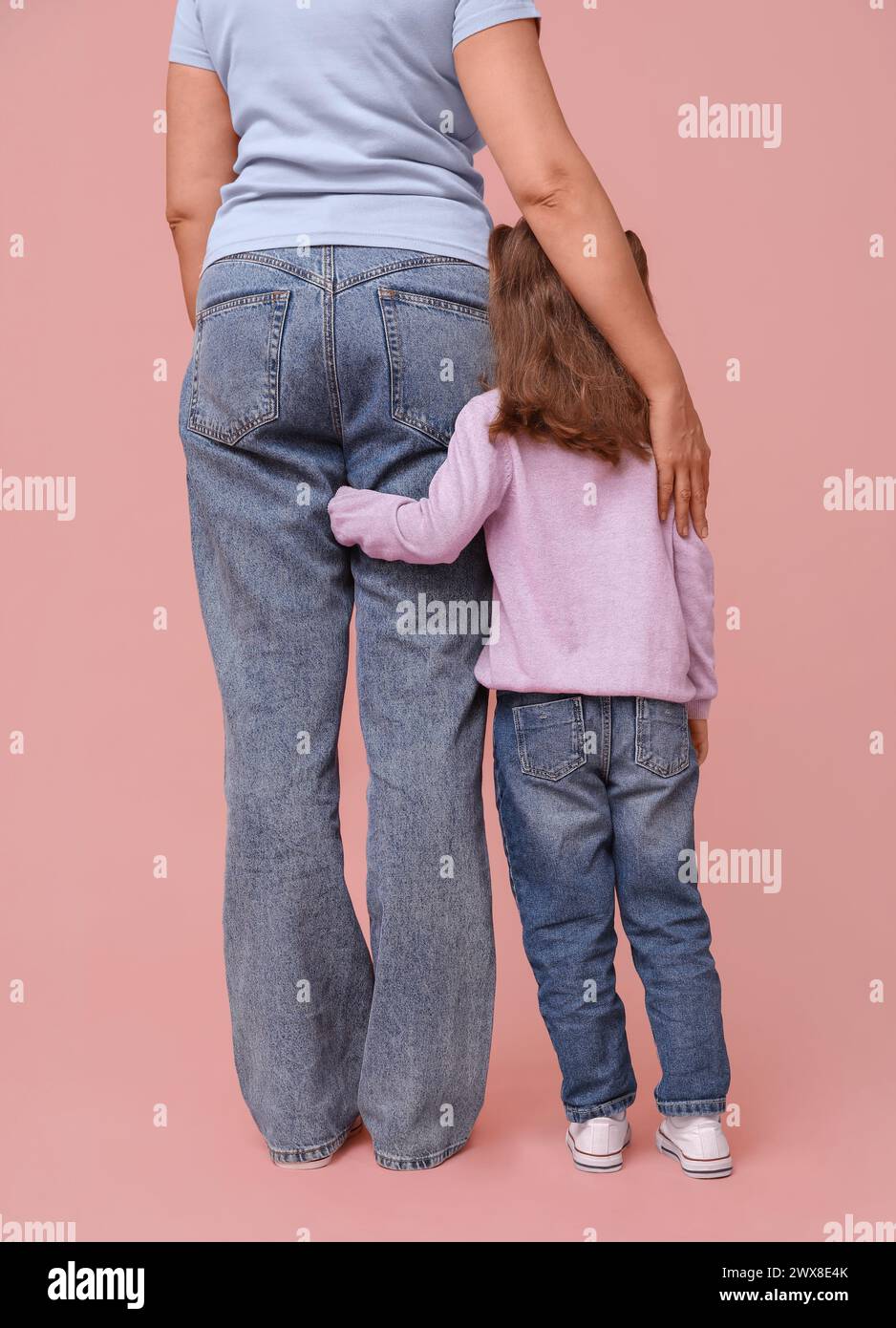 Happy family mother and daughter on pink background. Mother's Day. Back ...
