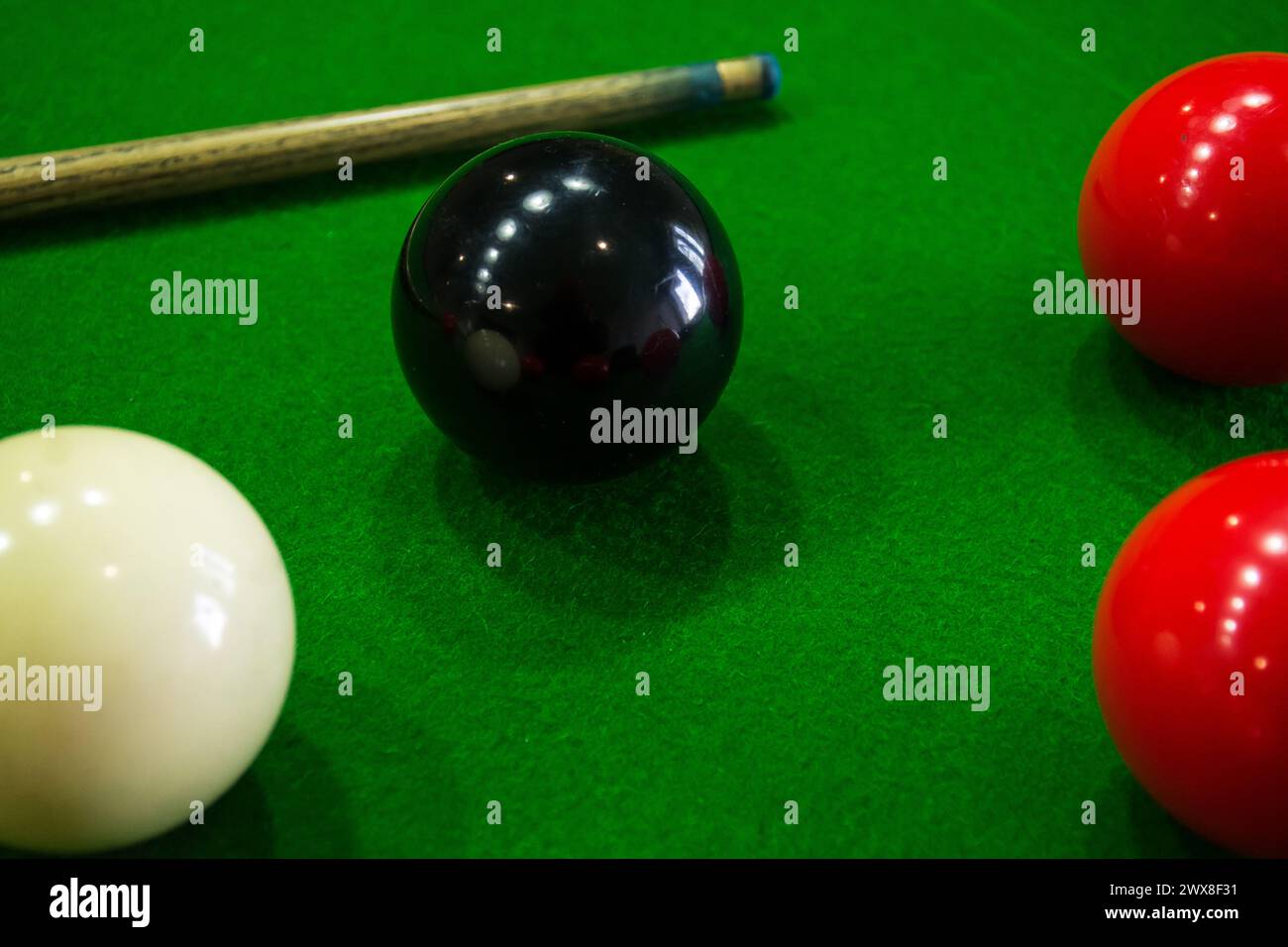 Billiards table with cues, balls, and a cue stick placed beside it ...