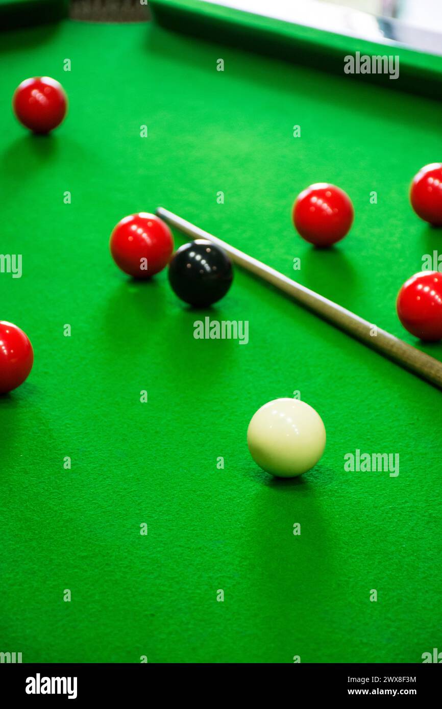 Pool balls, cues, and a cue on the table in a pool hall Stock Photo - Alamy