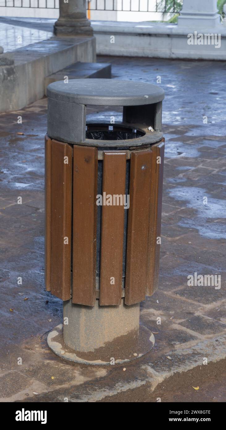 Modern urban trash bin, reflecting light on wet pavement, with eco ...